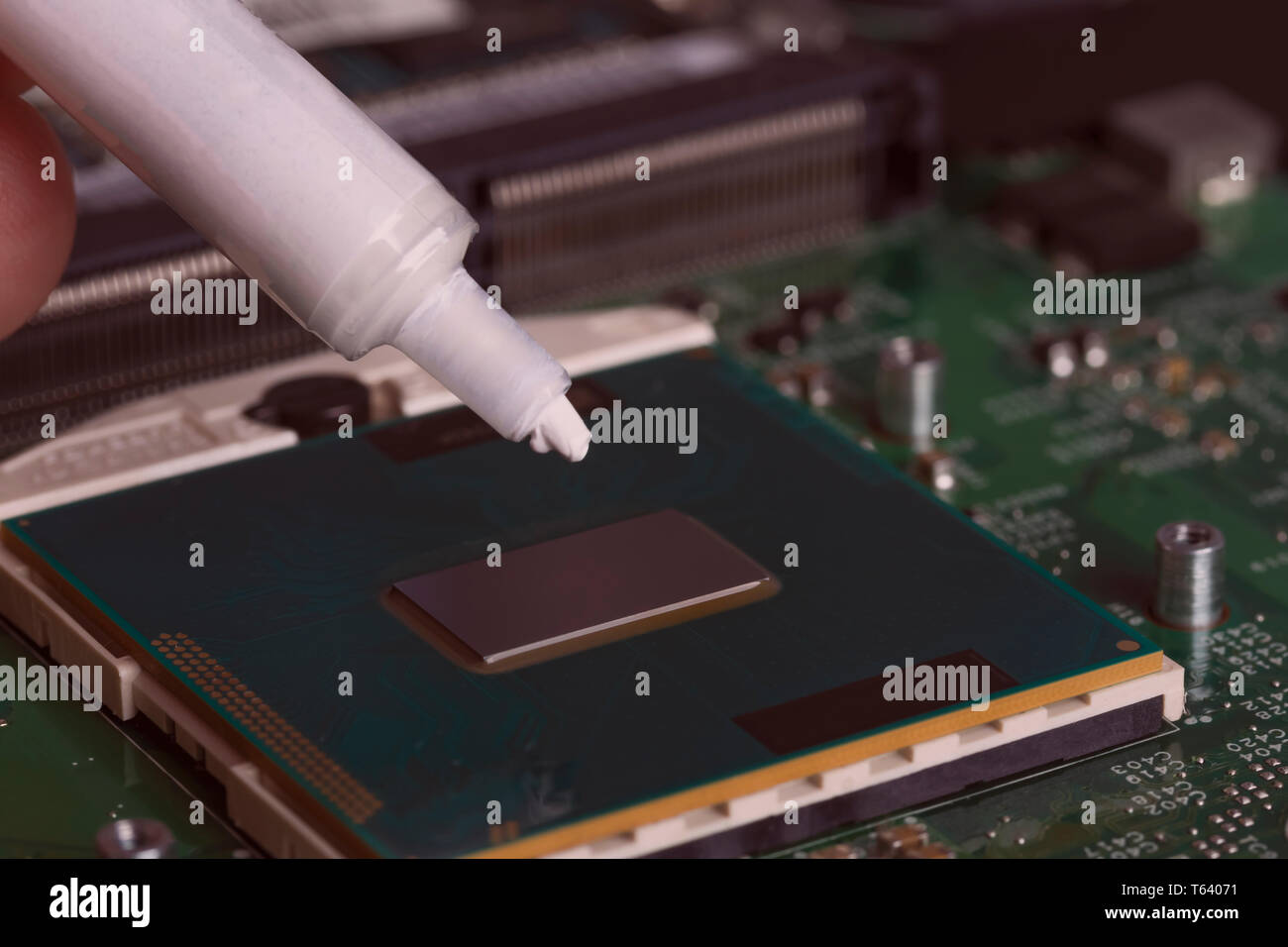 A tube of thermal grease over the processor chip. Computer assembly ...