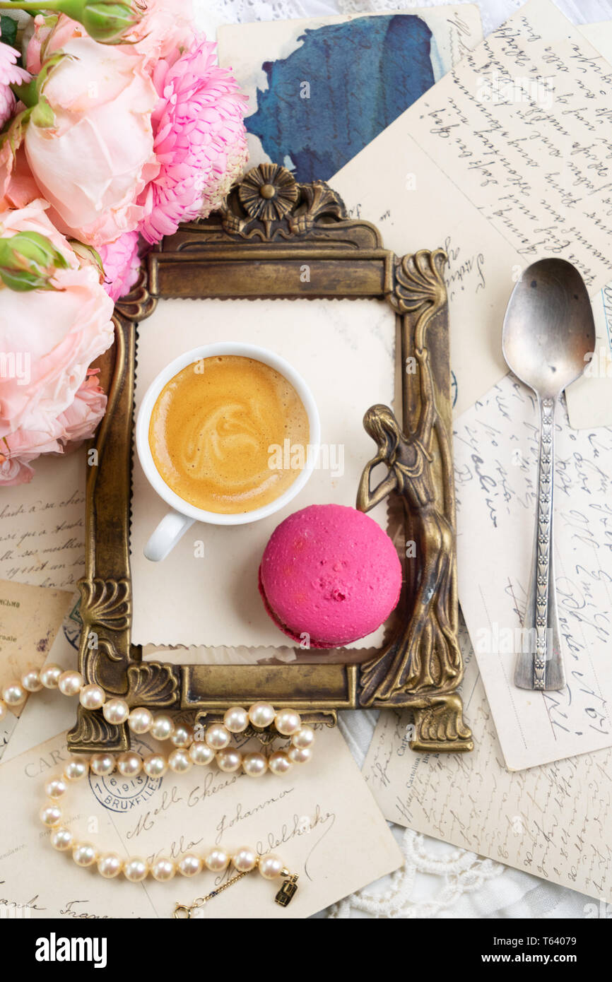 Pink flowers with cup of fresh brewed coffee on pile of old mail Stock ...