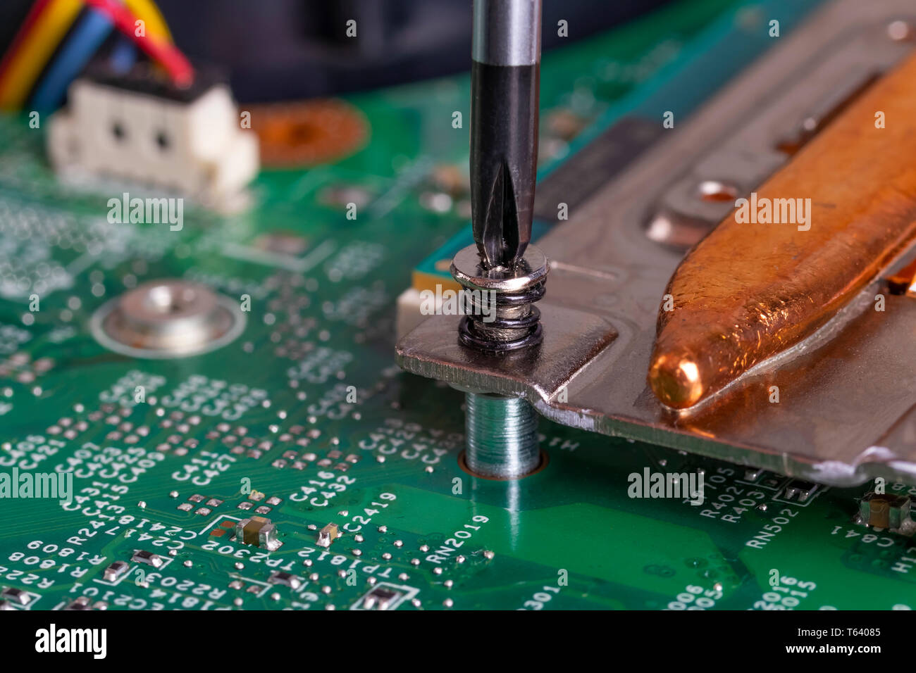 A screwdriver unscrews the mounting bolt of the computer board ...