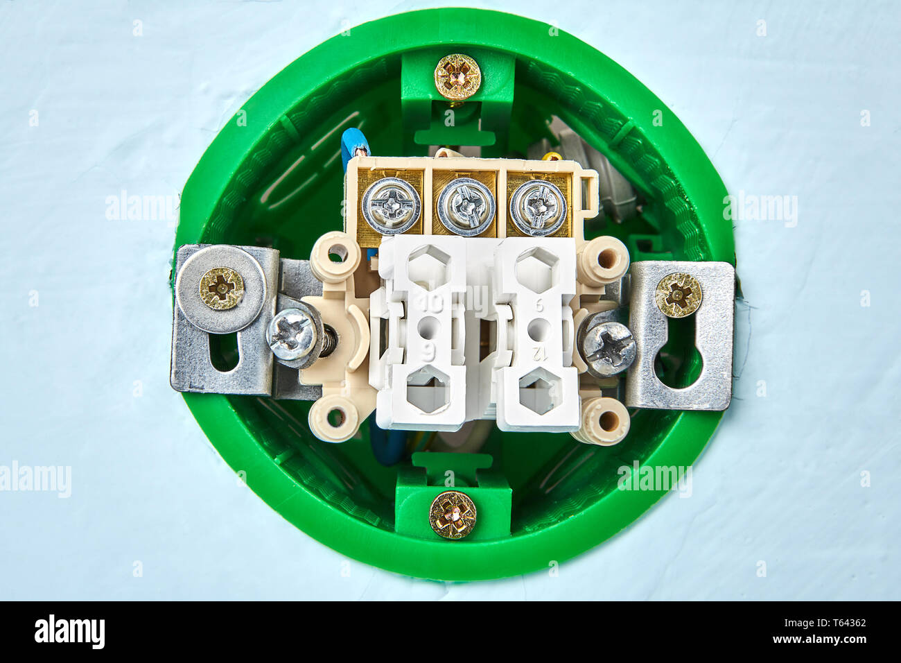 Round green two-button switch in process of mounting inside drywall ...