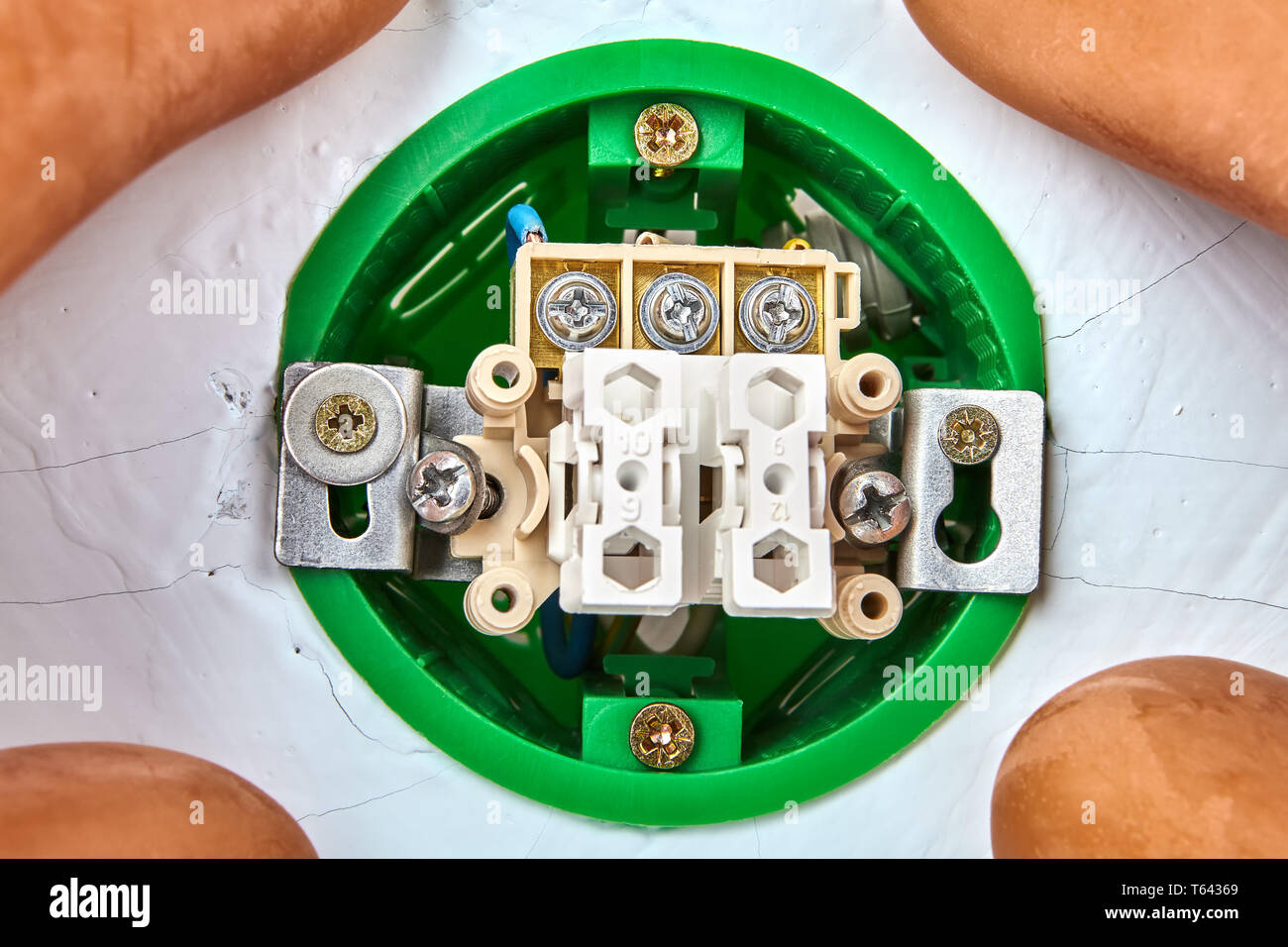 Round green european standard push button in process of installation ...