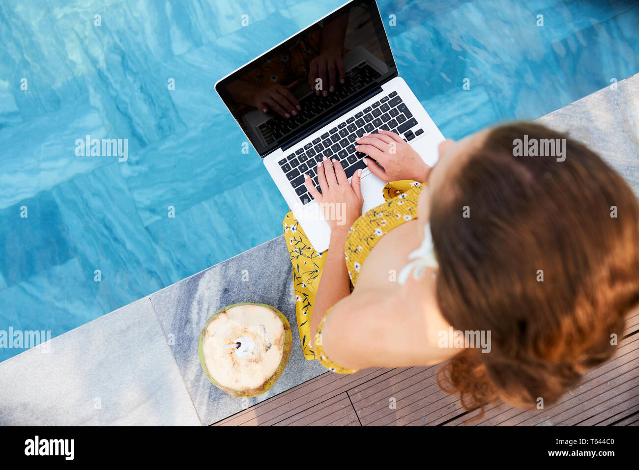 Woman working by pool Stock Photo - Alamy