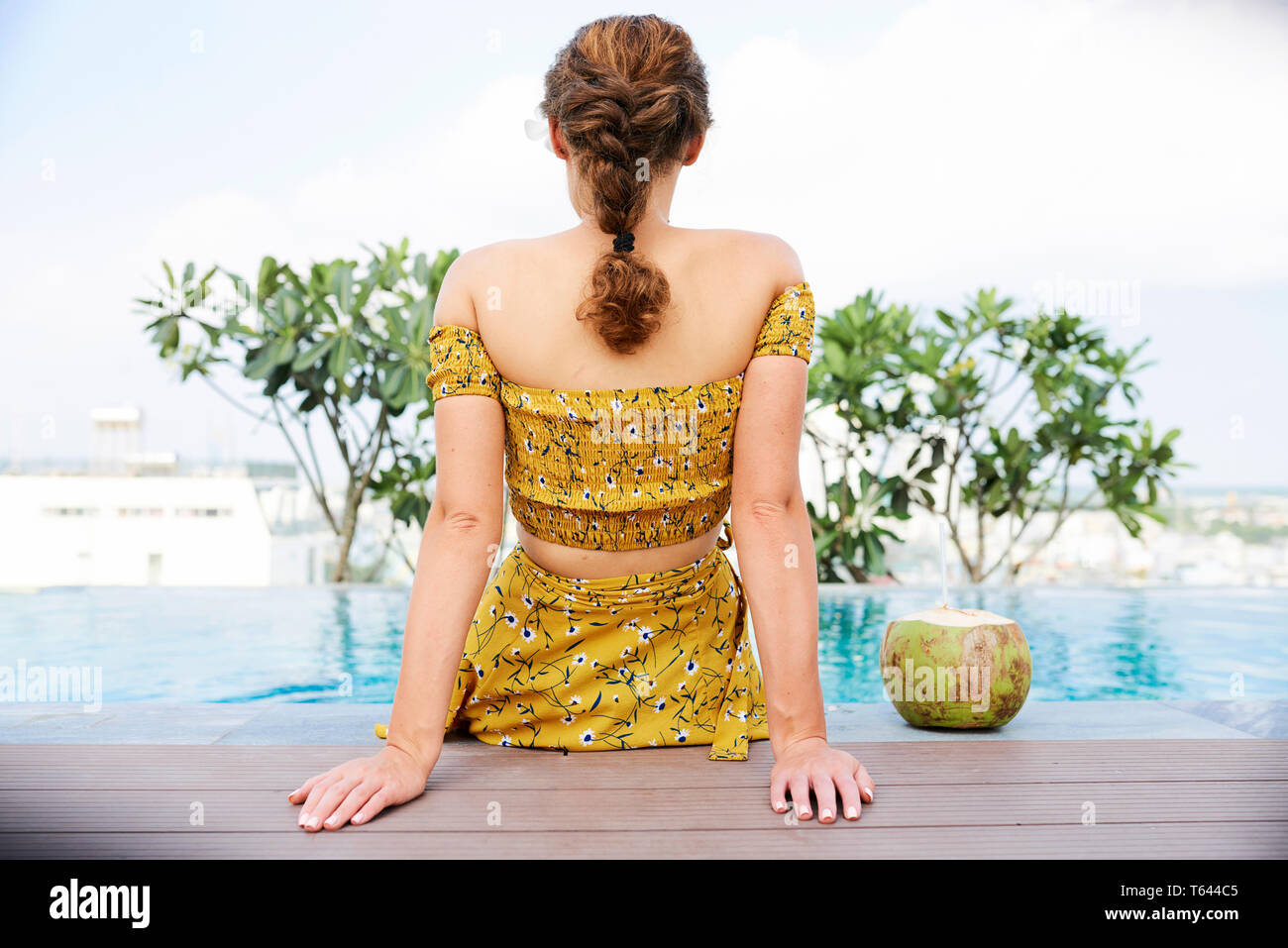 Young woman resting by pool Stock Photo - Alamy