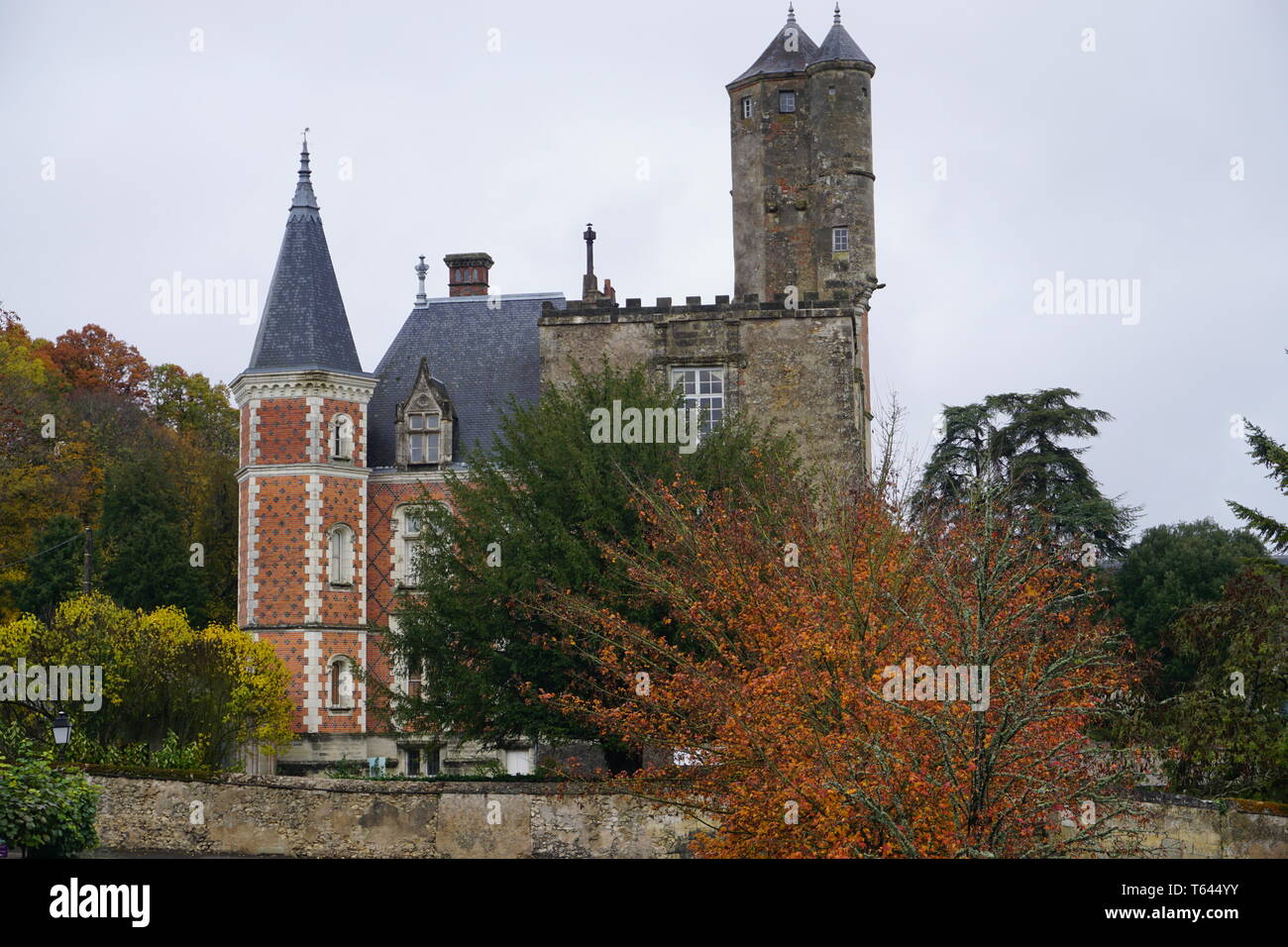 unusual stone tower on an old red brick castle in the country in France ...