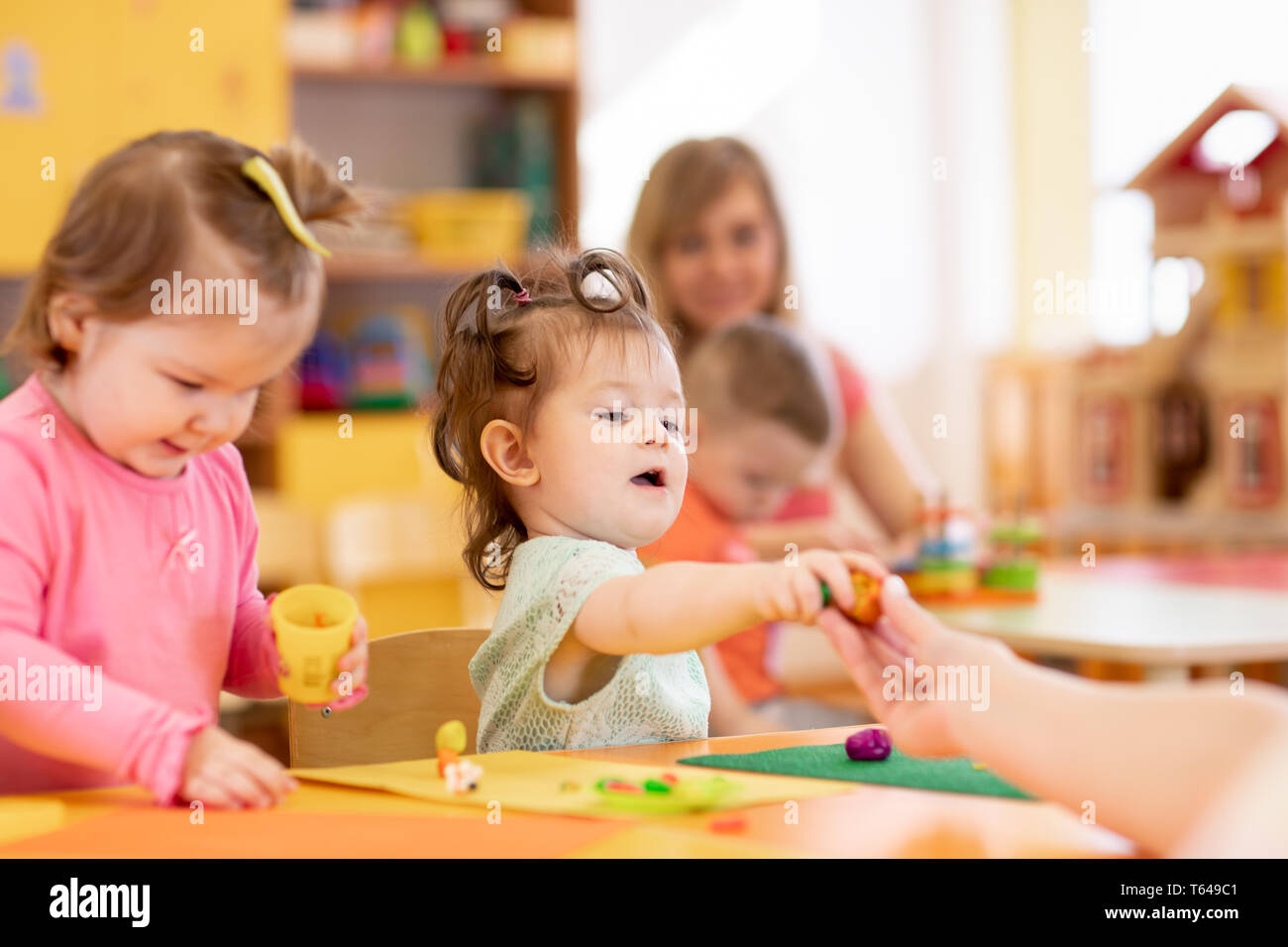 Little kid girl learning to use colorful play dough in kindergarten ...