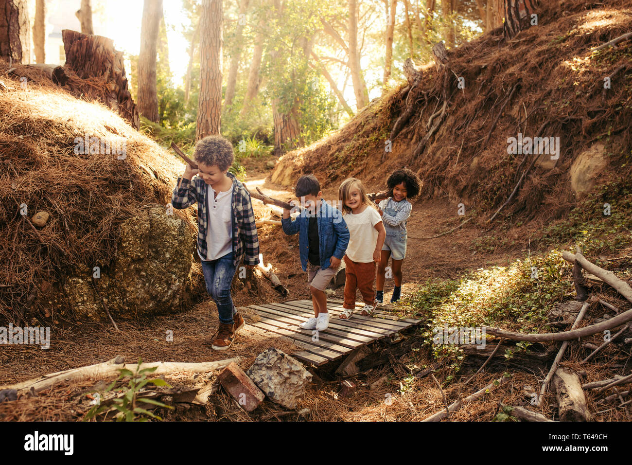 Group of children building camp in forest together. Boys and girls ...