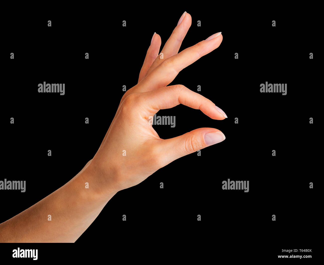 Woman hand holding something with two fingers on black background ...