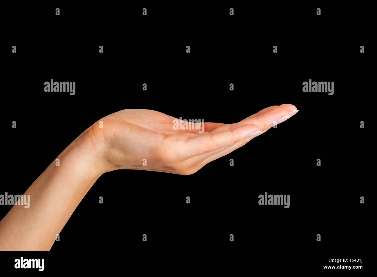 Woman showing open hand or holding something on black background ...