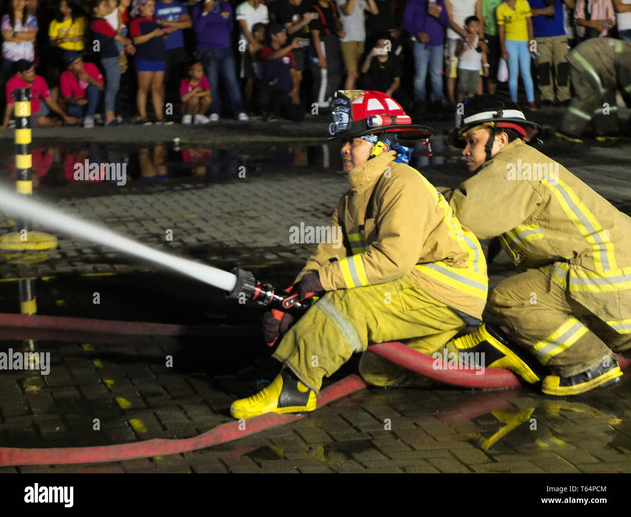 Pasay City, Philippines. 14th Jan, 2012. Fire fighters are seen keeping ...