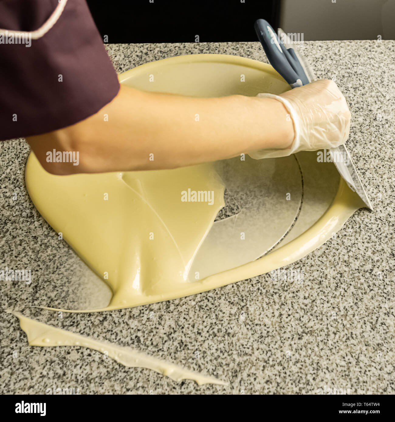 The process of making handmade chocolates. Tempering white chocolate ...