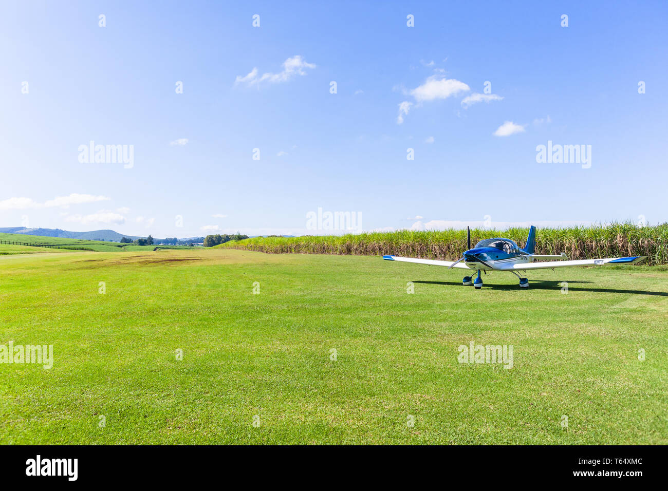 Light single prop aircraft plane parked on rural countryside farm grass ...