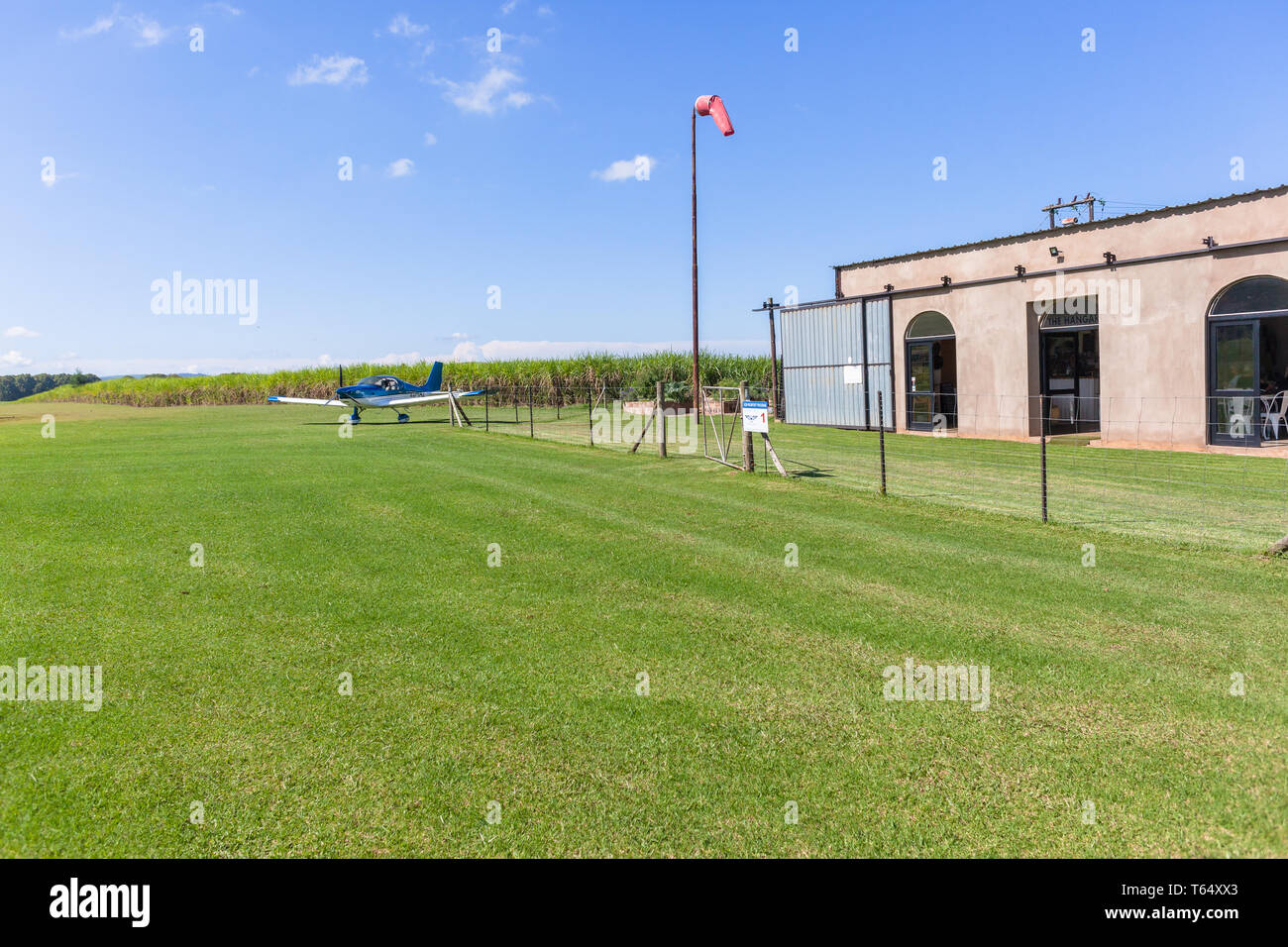 Light single prop aircraft plane parked on rural countryside farm grass ...