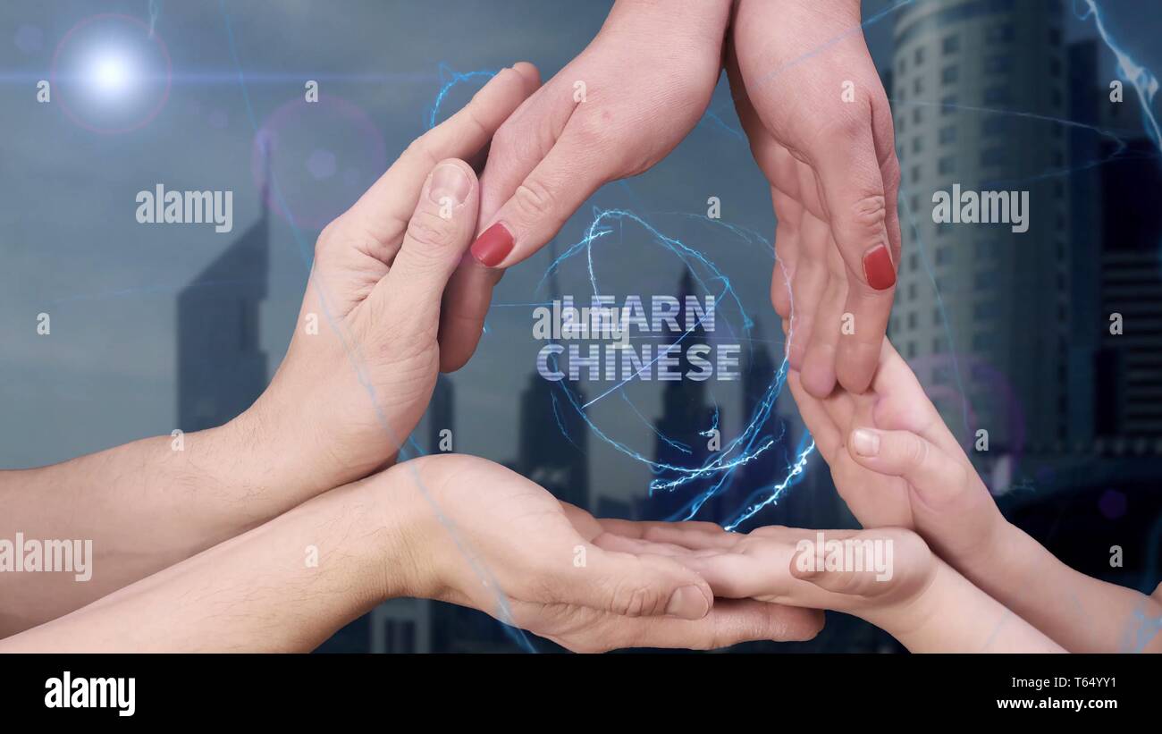 Men's, women's and children's hands show a hologram Learn Chinese Stock ...