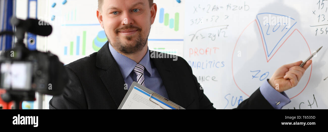 Male in suit and tie show stats graph pad Stock Photo - Alamy