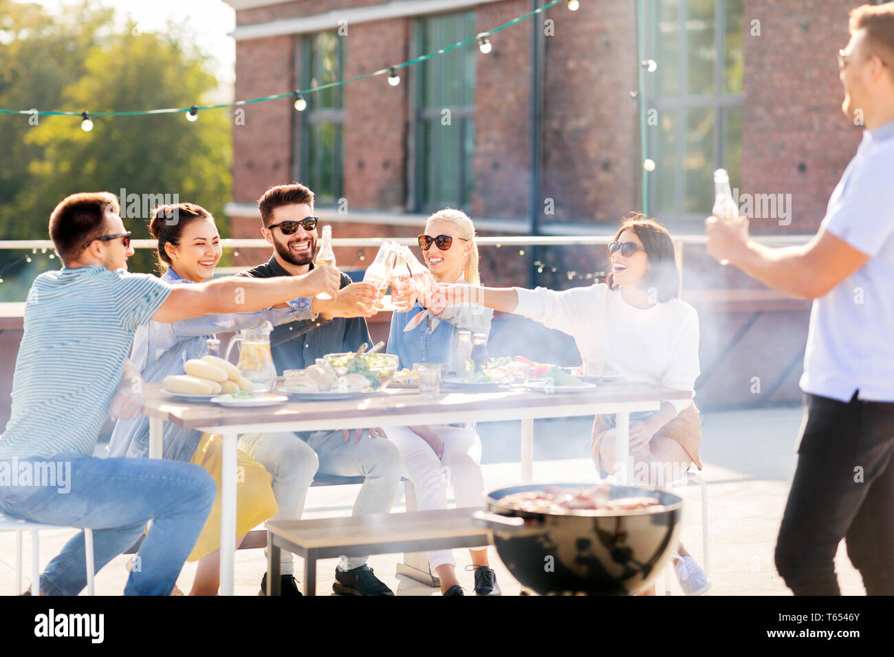 friends toast drinks at bbq party on rooftop Stock Photo - Alamy