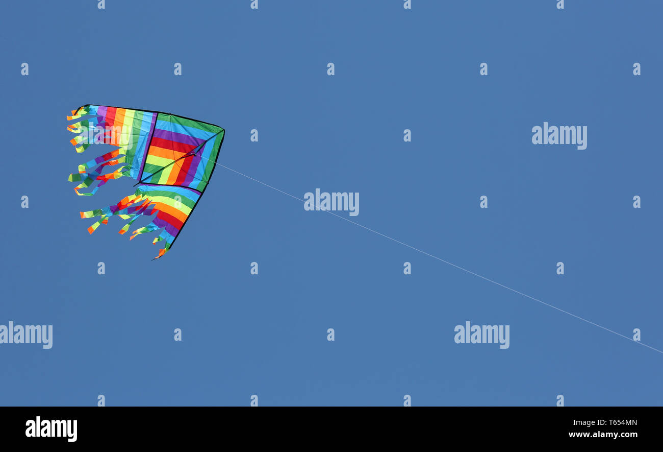 Multcolored kite on the blue sky with vivid colors Stock Photo - Alamy