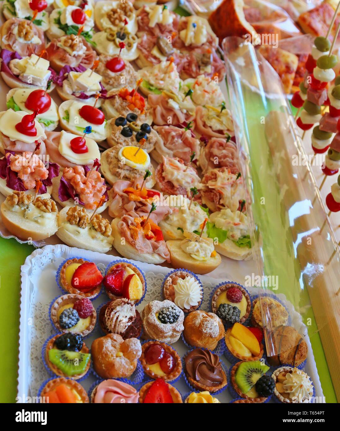 buffet with many trays overflowing with pastries and sandwiches Stock ...