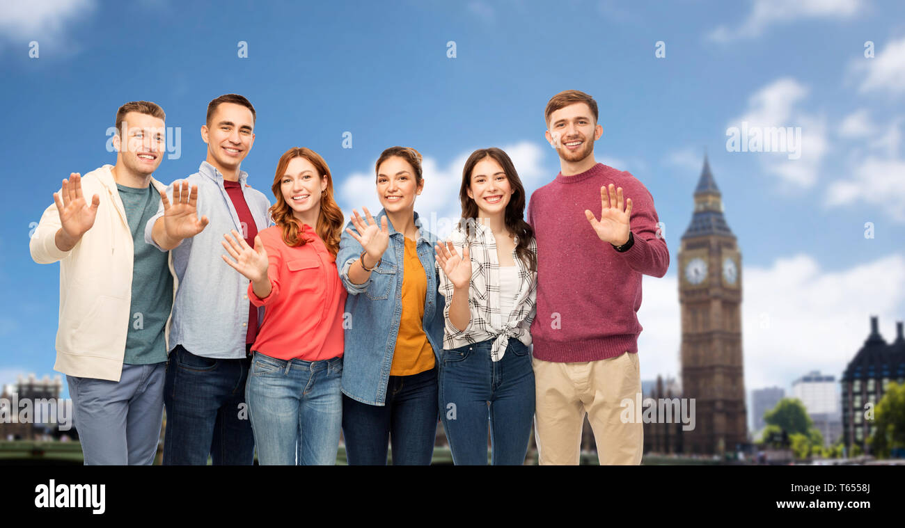 group of friends waving hands over london Stock Photo - Alamy