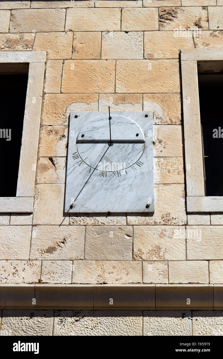 marble sun-dial between two windows Stock Photo - Alamy