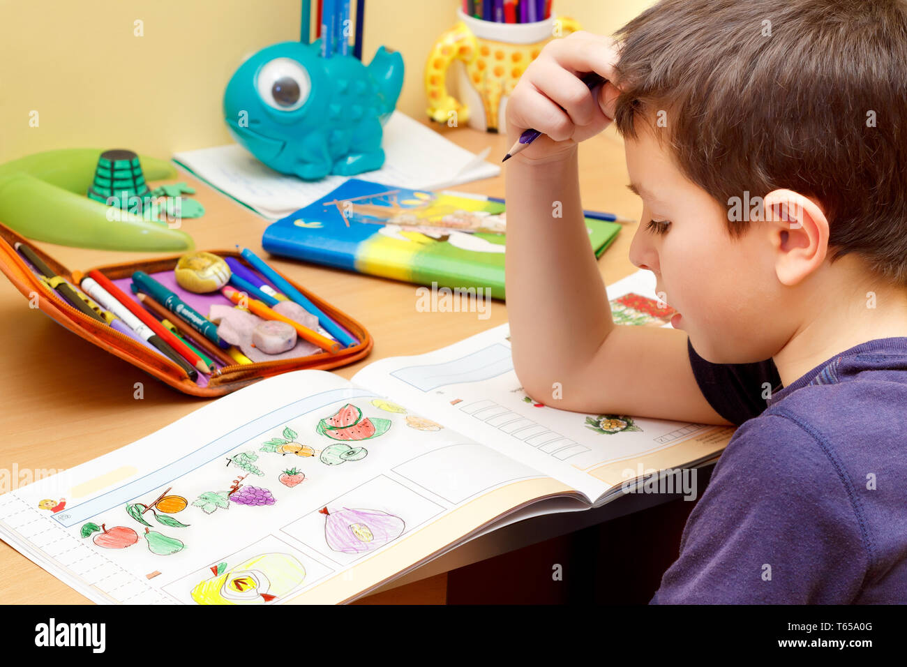 boy doing homework with color pencil Stock Photo - Alamy