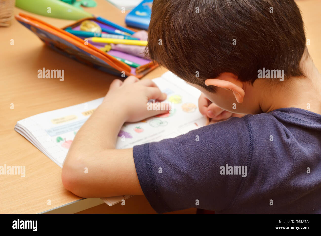 boy doing homework with color pencil Stock Photo - Alamy