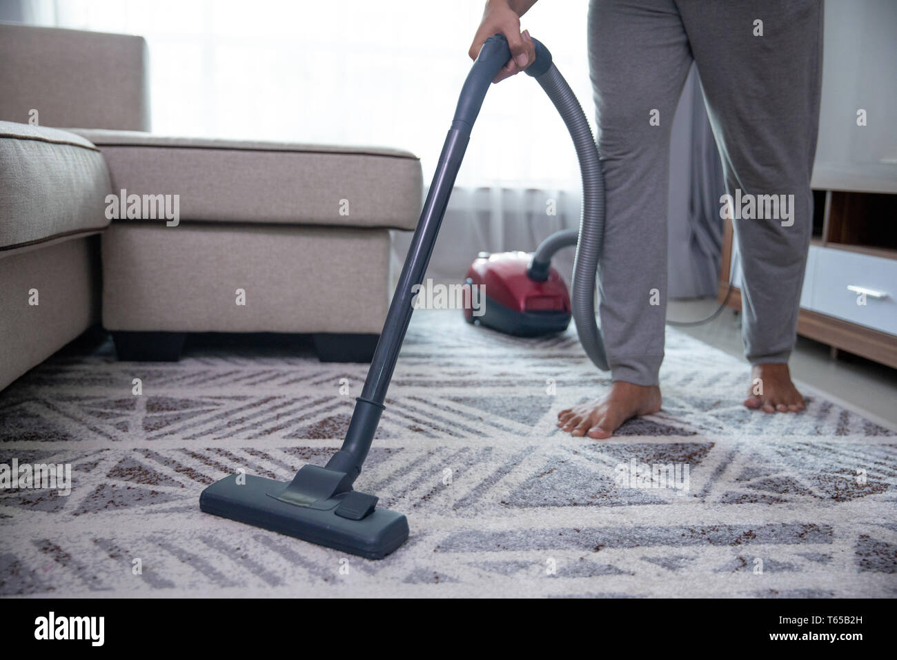 man hand vacuuming carpet Stock Photo - Alamy