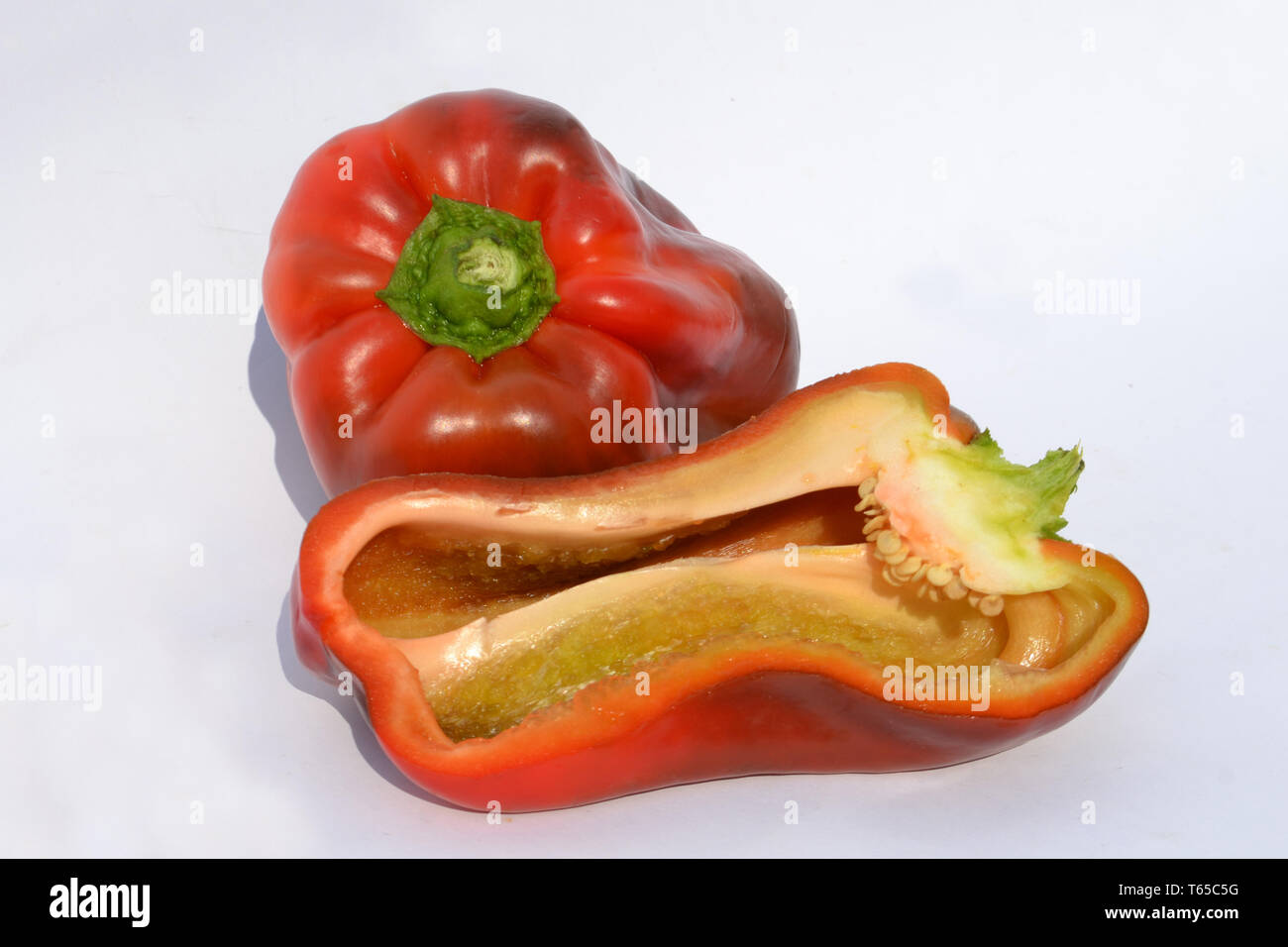 Beautiful close-up view to one whole and one half cut red bell peppers ...