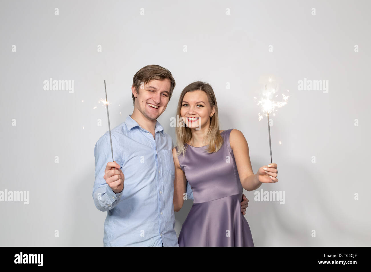 Celebration, party and holiday concept - Happy man and woman hugging over grey background with ...