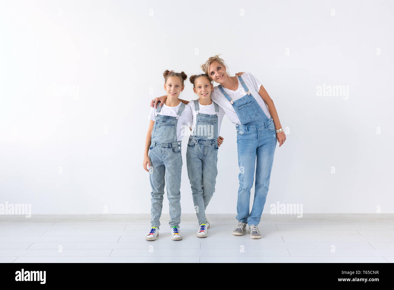 people, family and children concept - twin sisters with their mom on ...