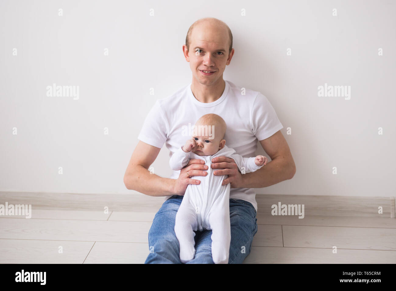 Infant, family and children concept - Bald father takes care of his ...