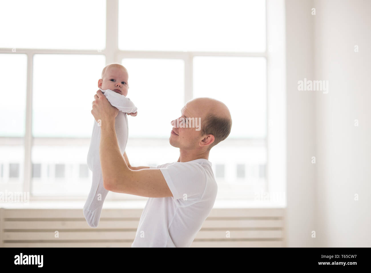 Parenting, family and fatherhood concept - cute bald dad and baby ...