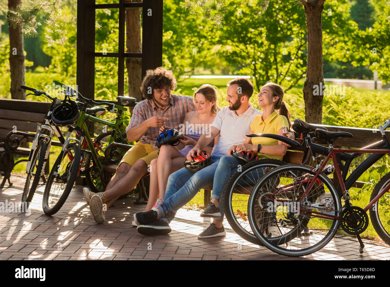 Four friends having rest in park Stock Photo - Alamy