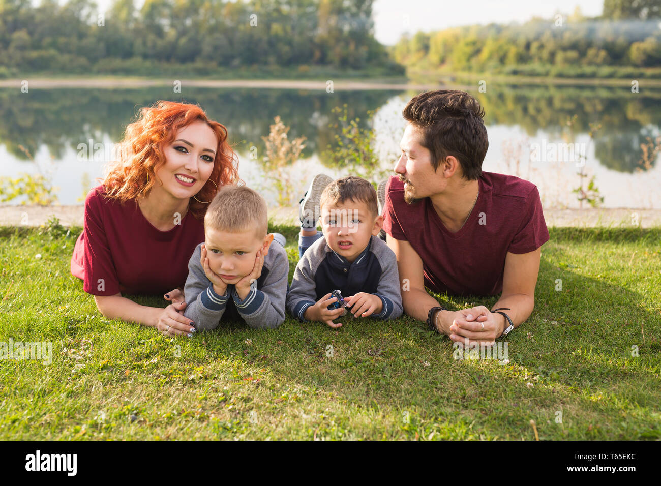 Parenthood, nature, people concept - family with two sons lying near ...