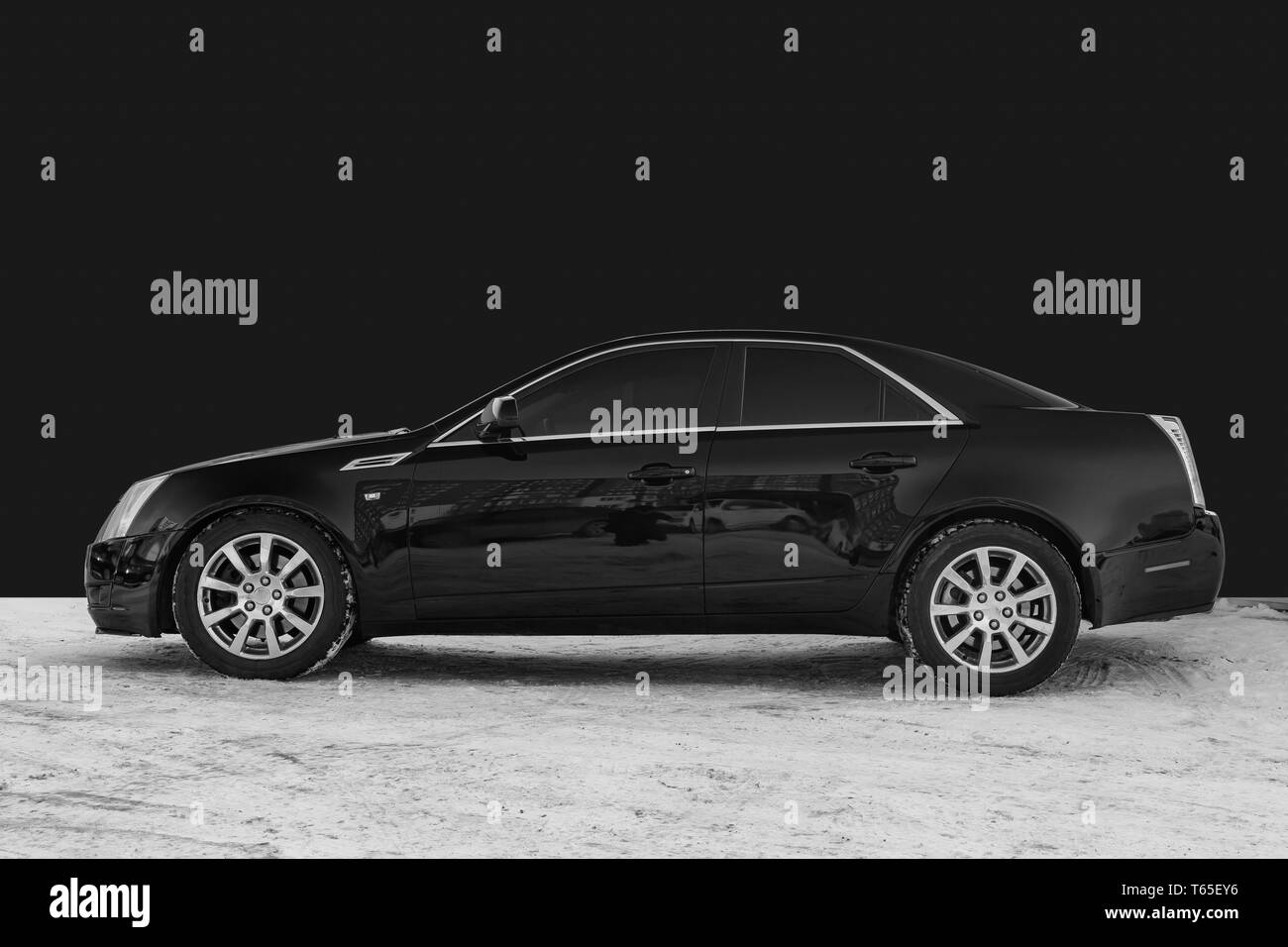 The left side of the car is black with chrome wheels on a black ...
