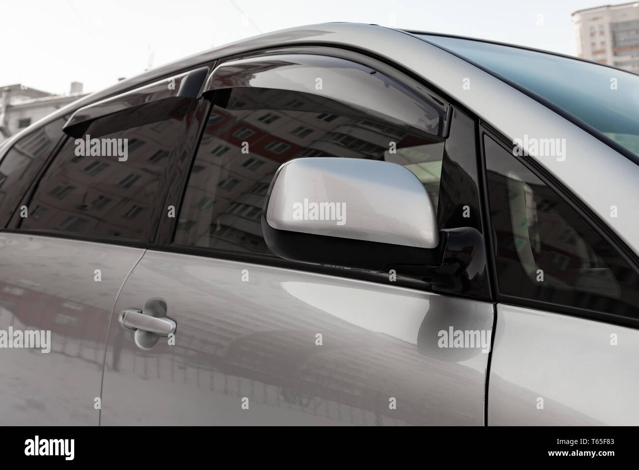 Close-up of the side left mirror with turn signal repeater and window ...