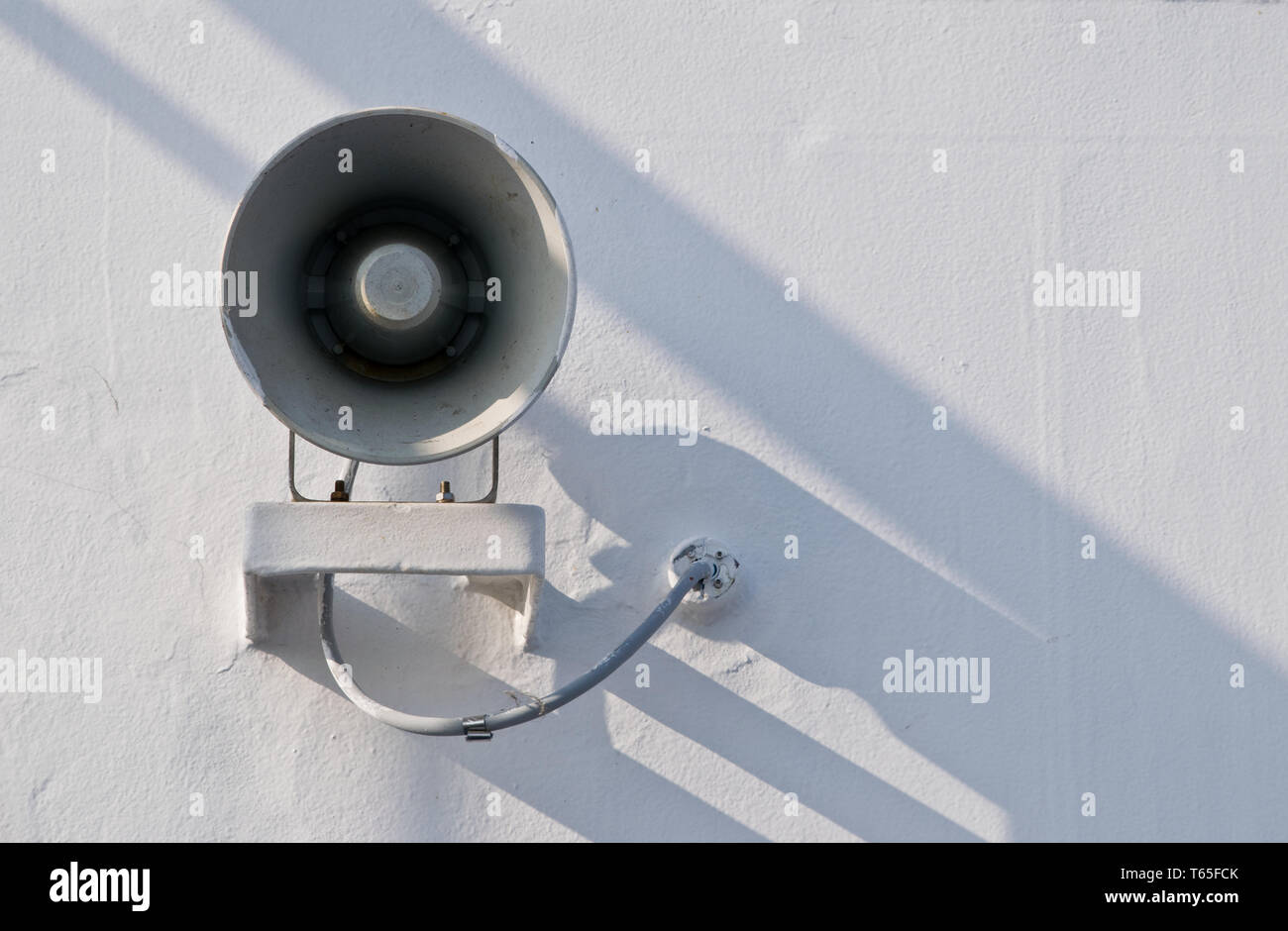 Old megaphone hanging on white wall background Stock Photo - Alamy
