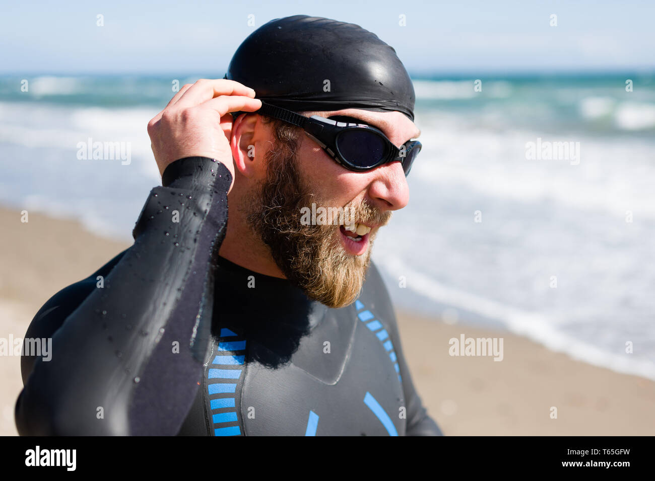 Triathlon man in wetsuit on the beach Stock Photo - Alamy