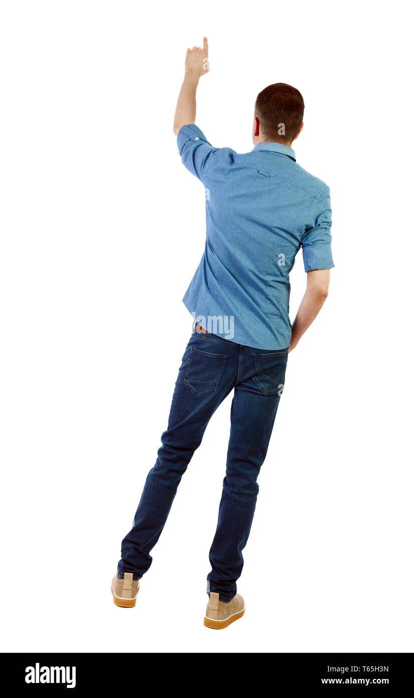 Back view of a man in jeans points his hand upwards. Rear view people ...
