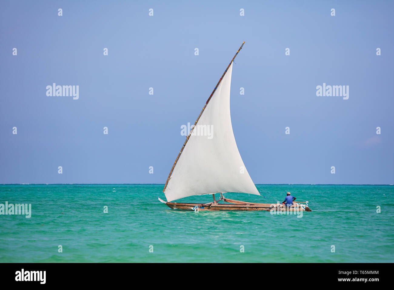 Sail boat with white sail sitting sailor sailing in the calm sea at ...