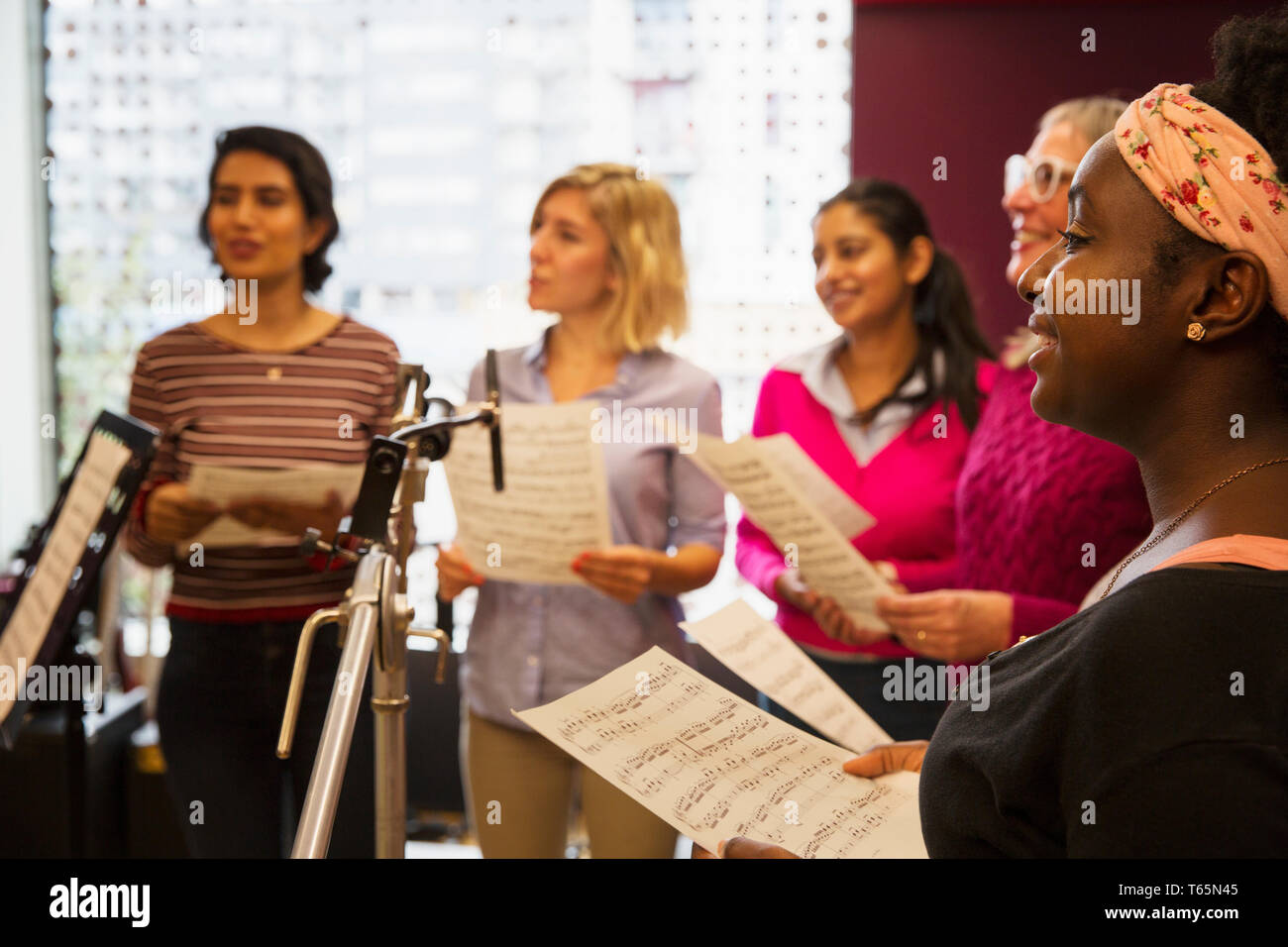Womens choir with sheet music singing in music recording studio Stock ...