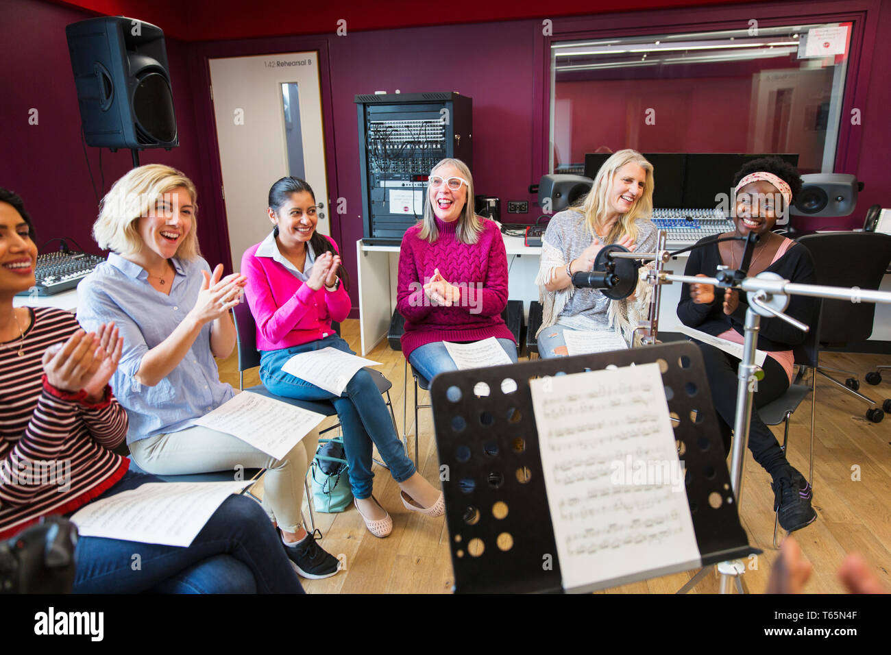 Womens choir with sheet music singing in music recording studio Stock ...