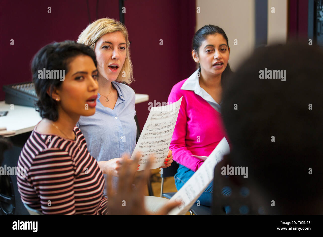 Womens choir with sheet music singing in music recording studio Stock ...