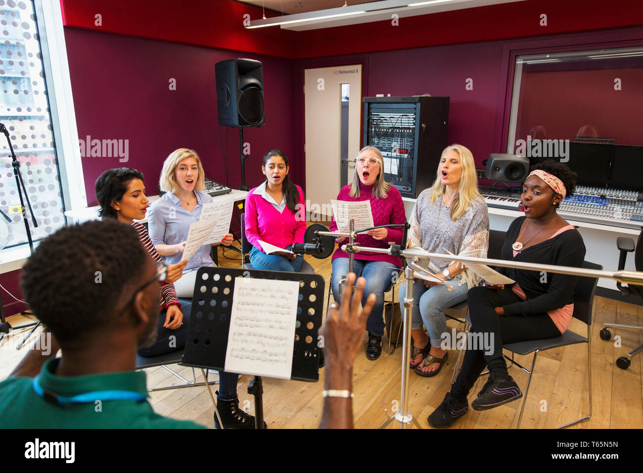 Womens choir with sheet music singing in music recording studio Stock ...