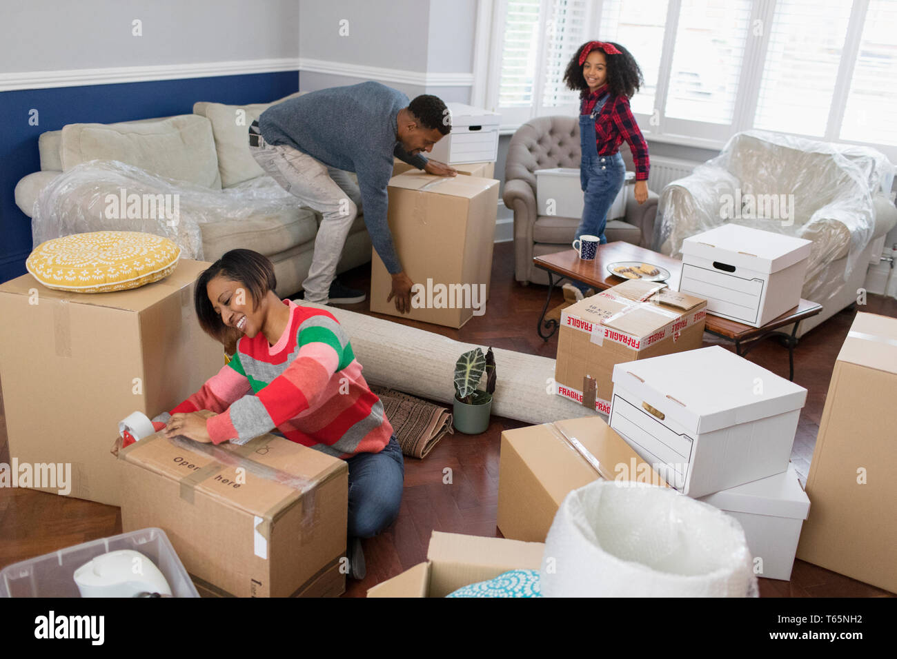 Family packing moving boxes, moving house Stock Photo - Alamy