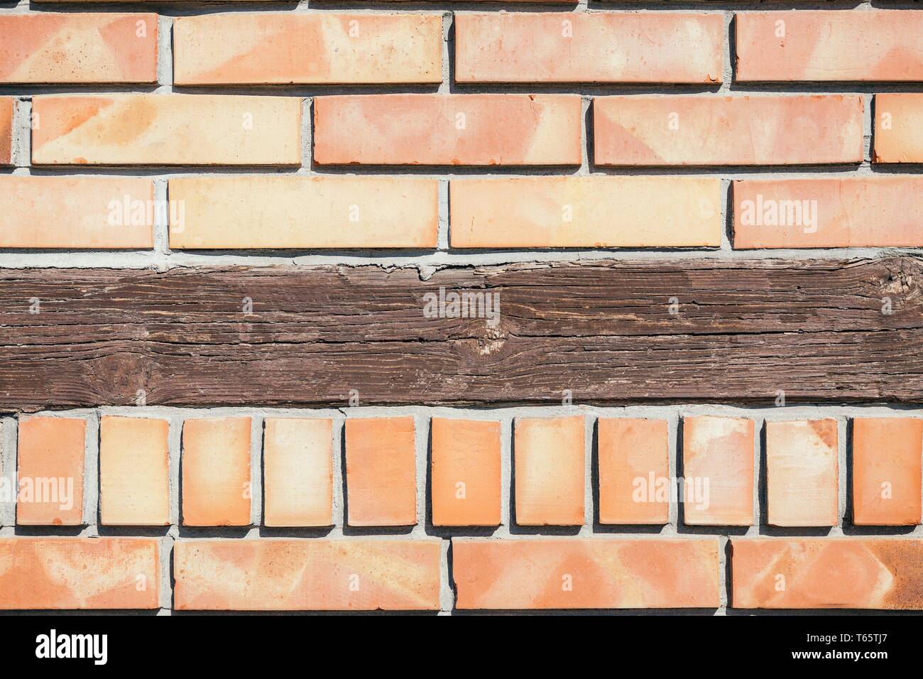 Light orange brick background with rustic brown wooden board. Copy ...