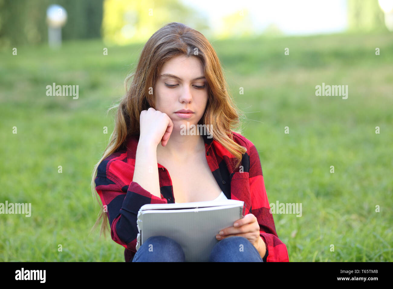 Front view portrait of a serious student studying memorizing notes on ...