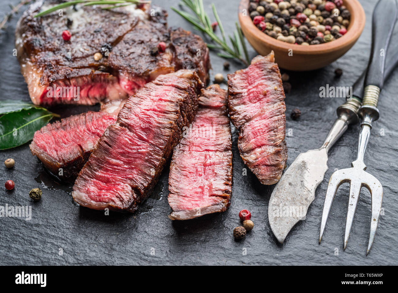 Medium rare Ribeye steak with herbs on graphite board Stock Photo - Alamy