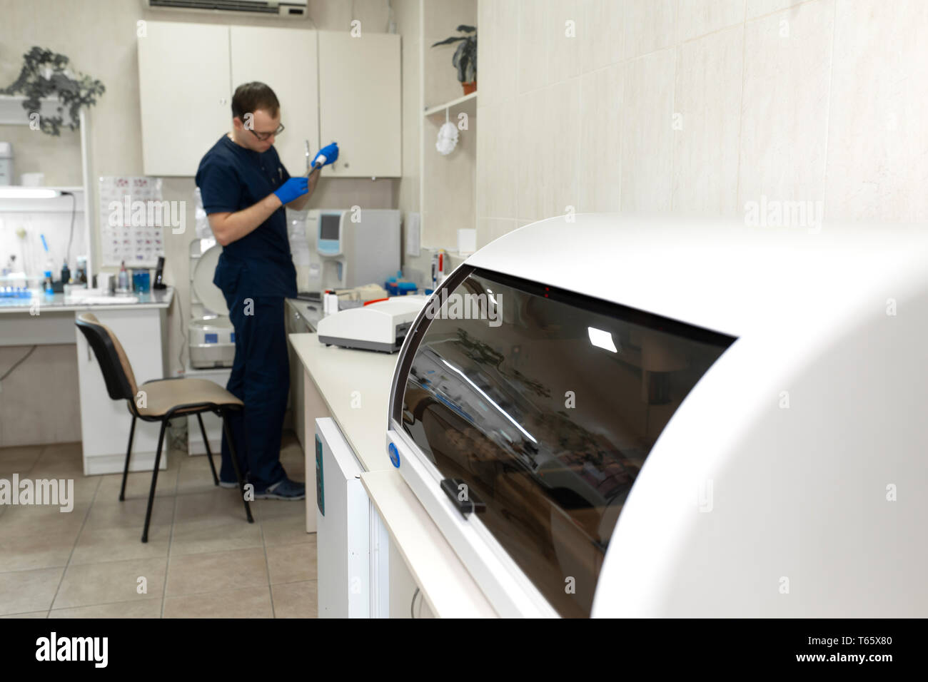 Laboratory assistant make test blood in automatical blood sample ...