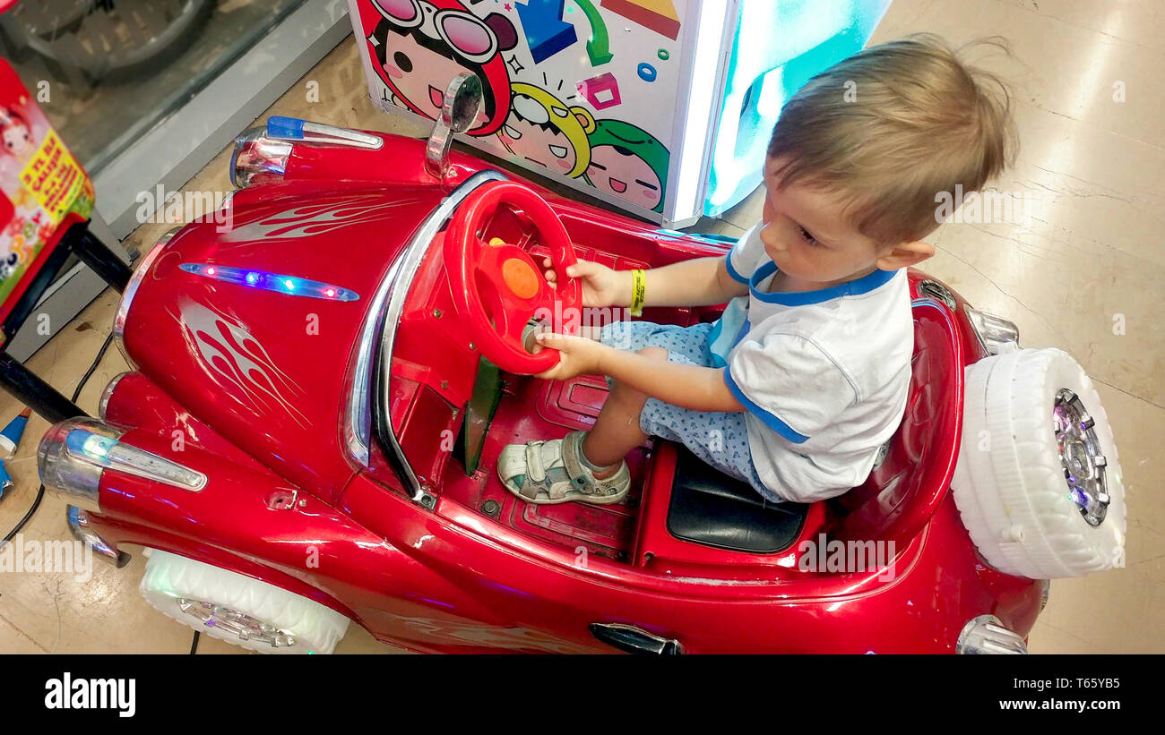 Little toddler boy having fun in amusement park. Child riding on insert ...