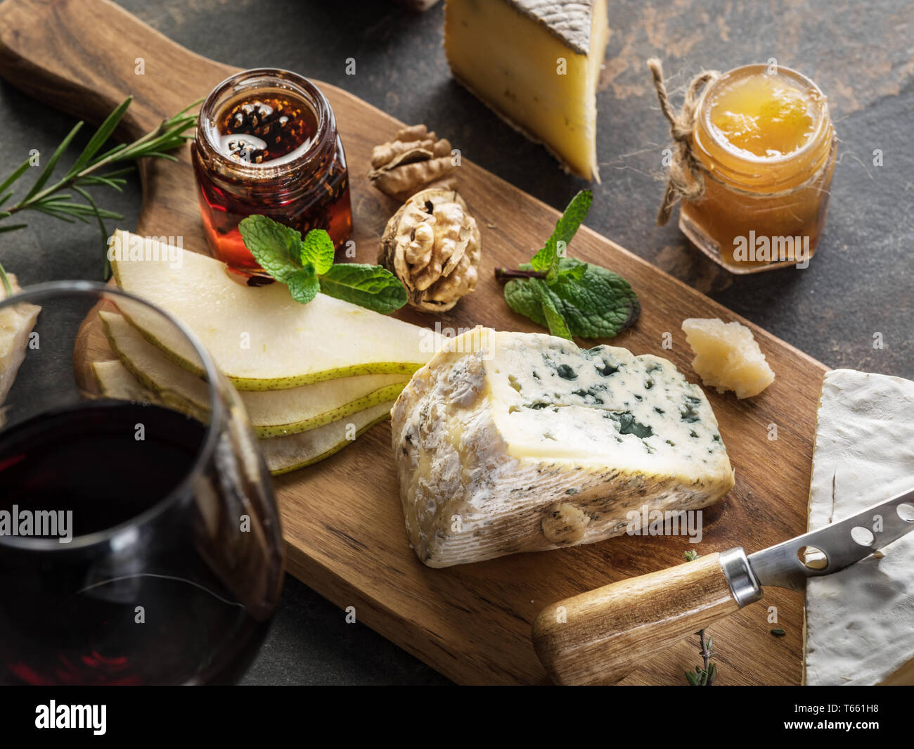 Cheese platter with different cheeses, fruits, nuts and wine on stone ...